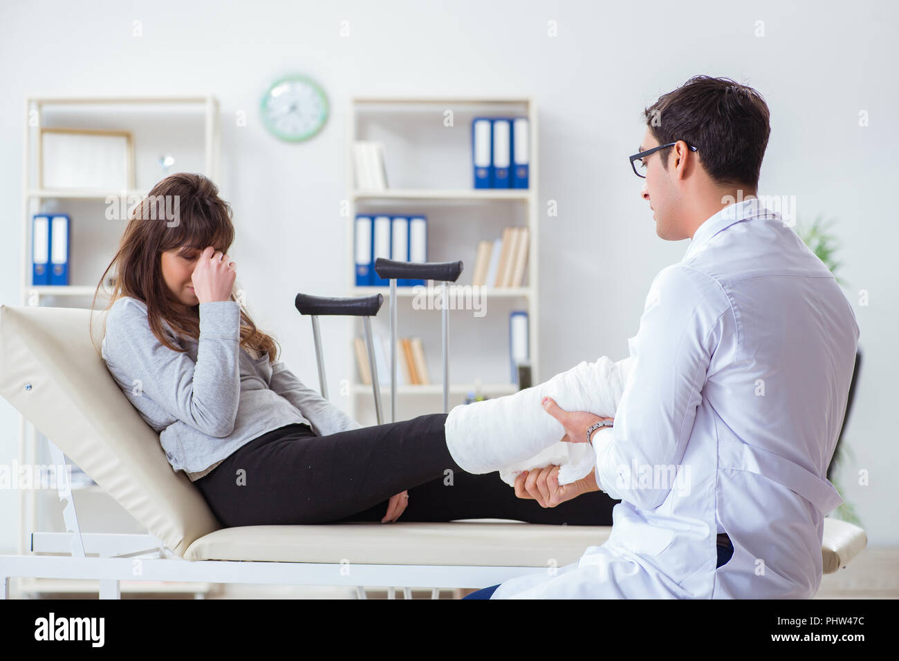 Doctor examining patient with broken leg Stock Photo - Alamy