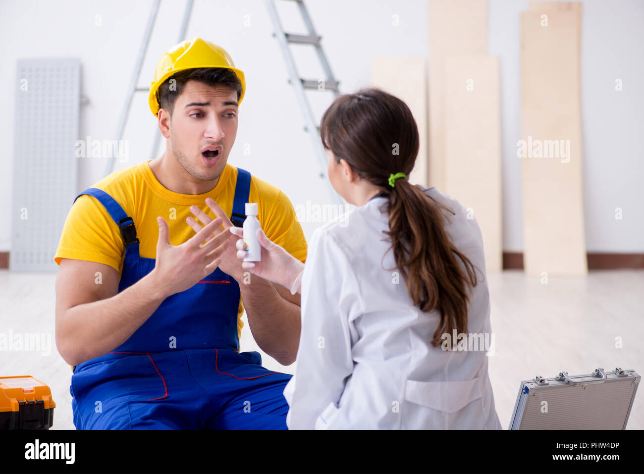 Doctor helping injured worker at construction site Stock Photo - Alamy