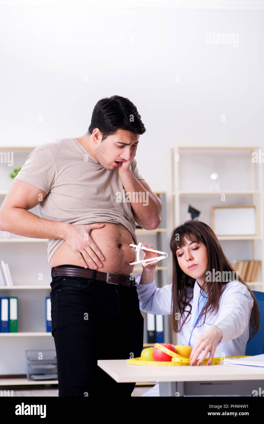 Doctor dietician giving advices to fat overweight patient Stock Photo ...