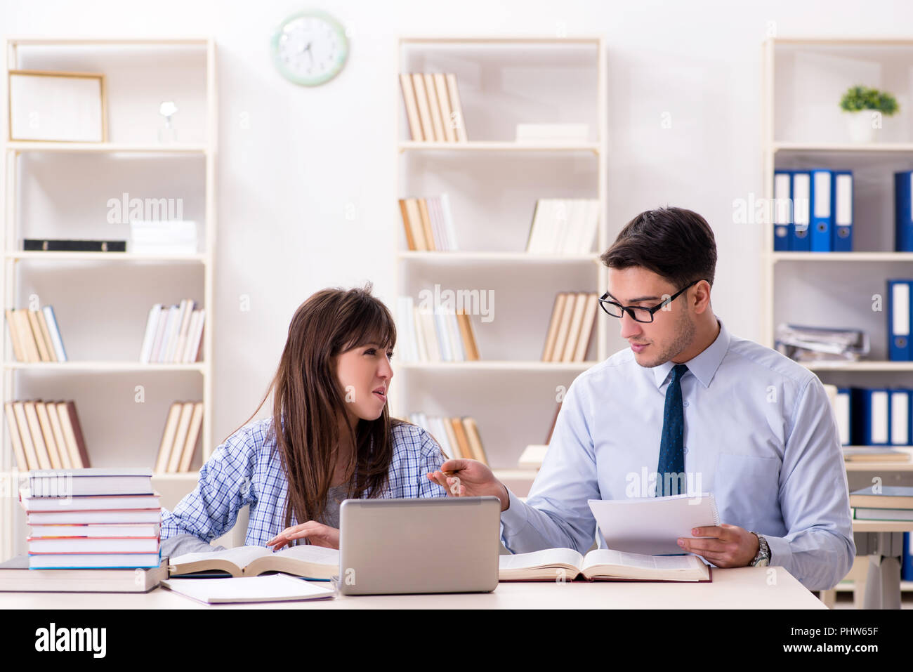 Male lecturer giving lecture to female student Stock Photo - Alamy