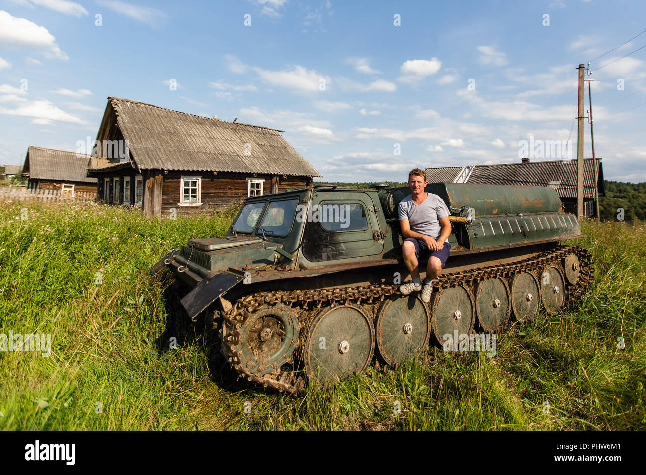 A man sits on the armor of old all-terrain vehicle in the Russian ...