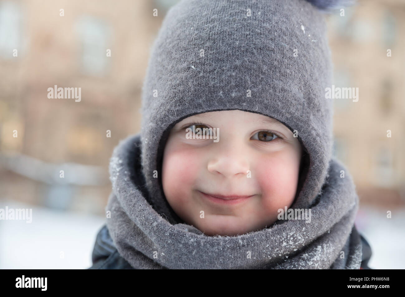 Child boy 4 years in winter outside in gray knitted woollen hat with ...
