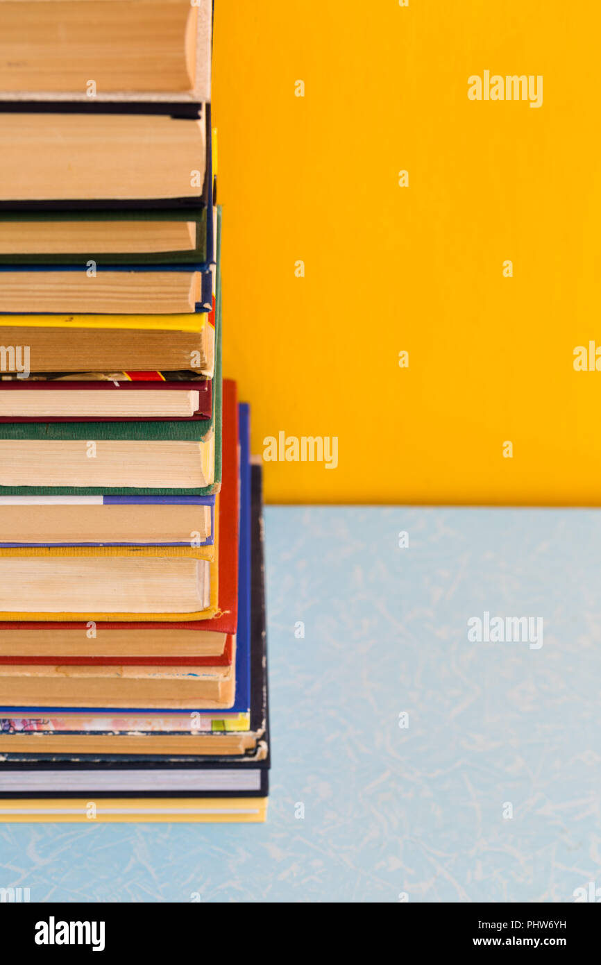 Stack of old books isolated on yellow background, vintage library ...