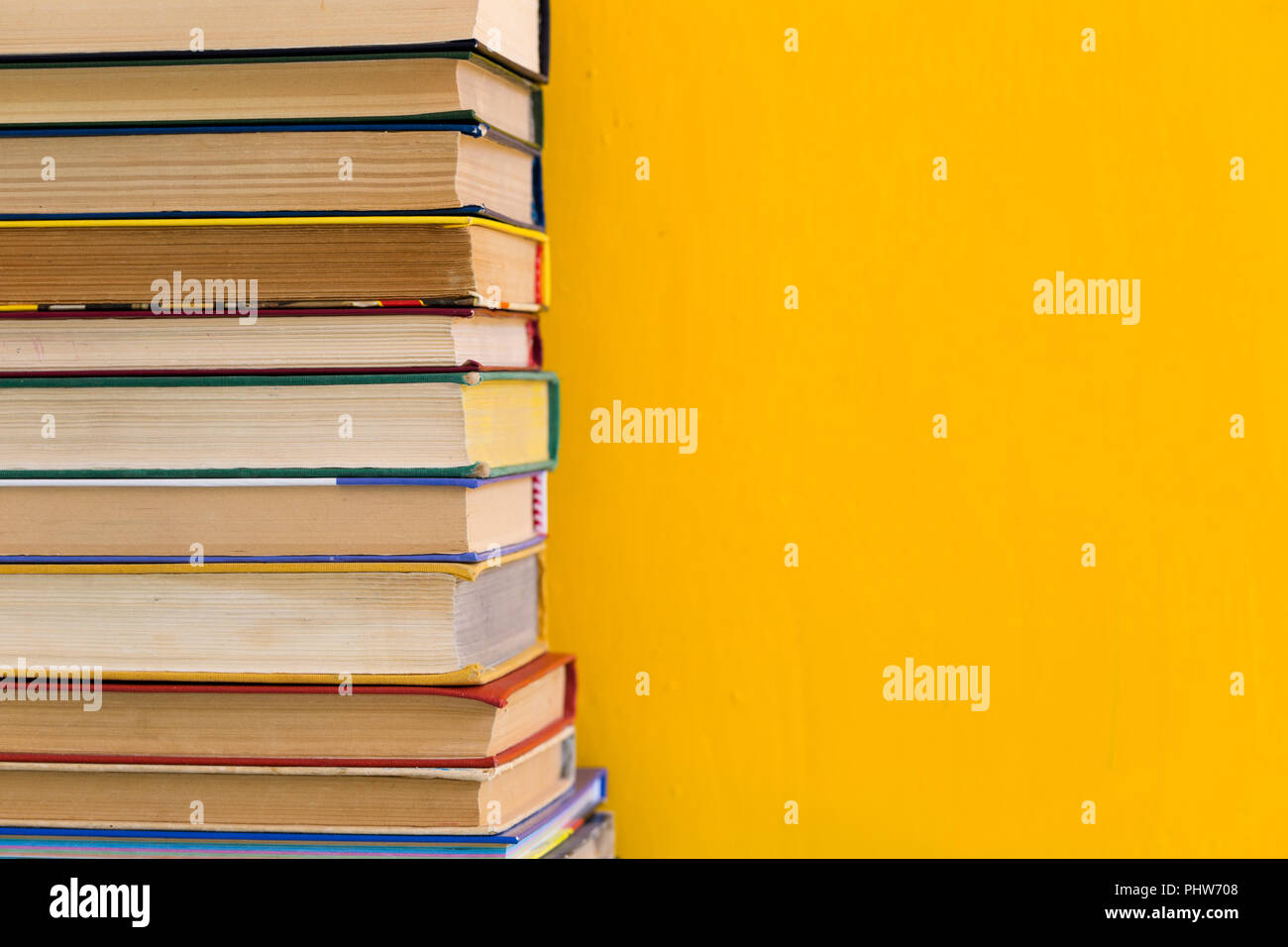 Stack of old books isolated on yellow background, vintage library ...