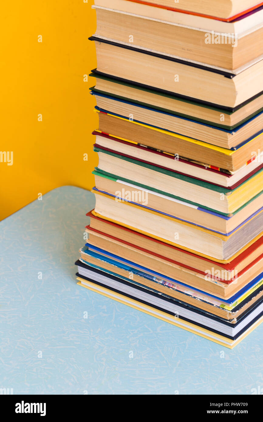 Stack of old books isolated on yellow background, vintage library ...