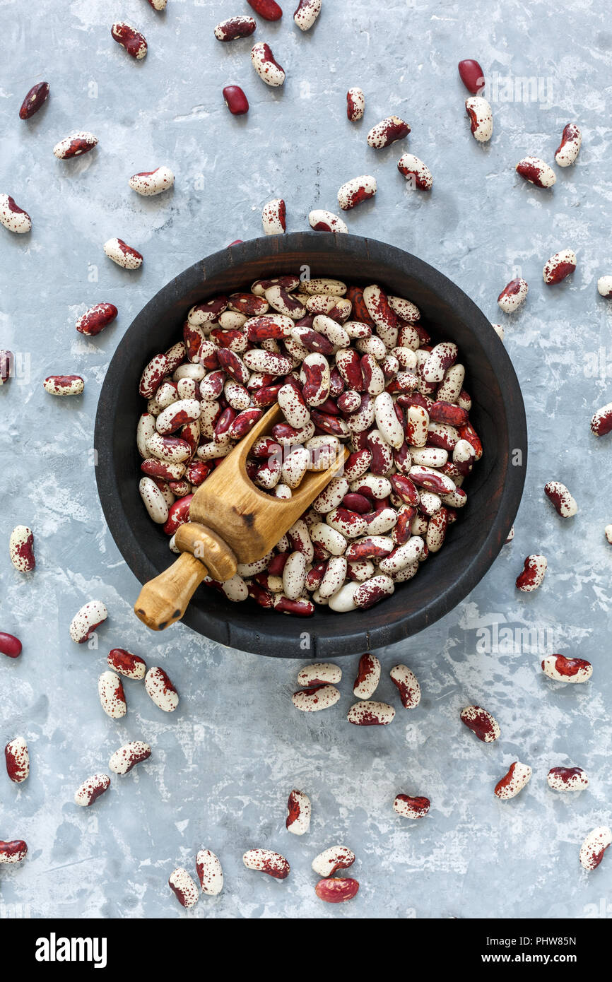 Motley beans and scoop in an old wooden bowl Stock Photo - Alamy