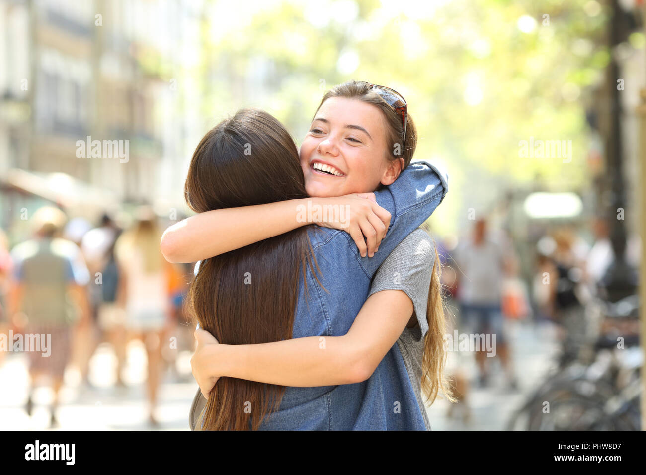 Two happy friends meeting and cuddling in the street Stock Photo - Alamy