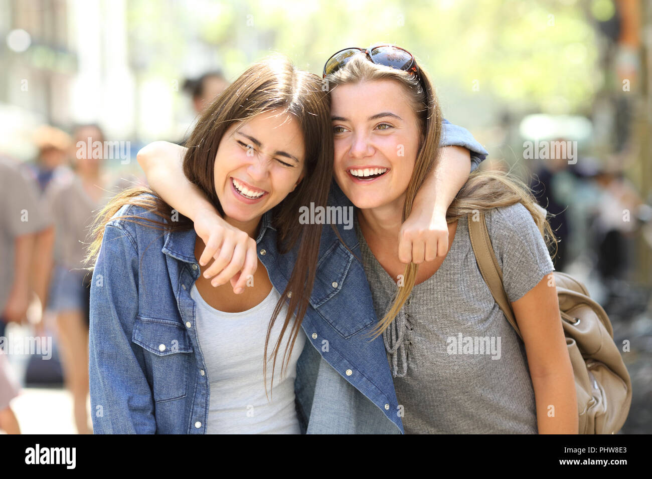 Two funny friends laughing loud walking in the street Stock Photo - Alamy