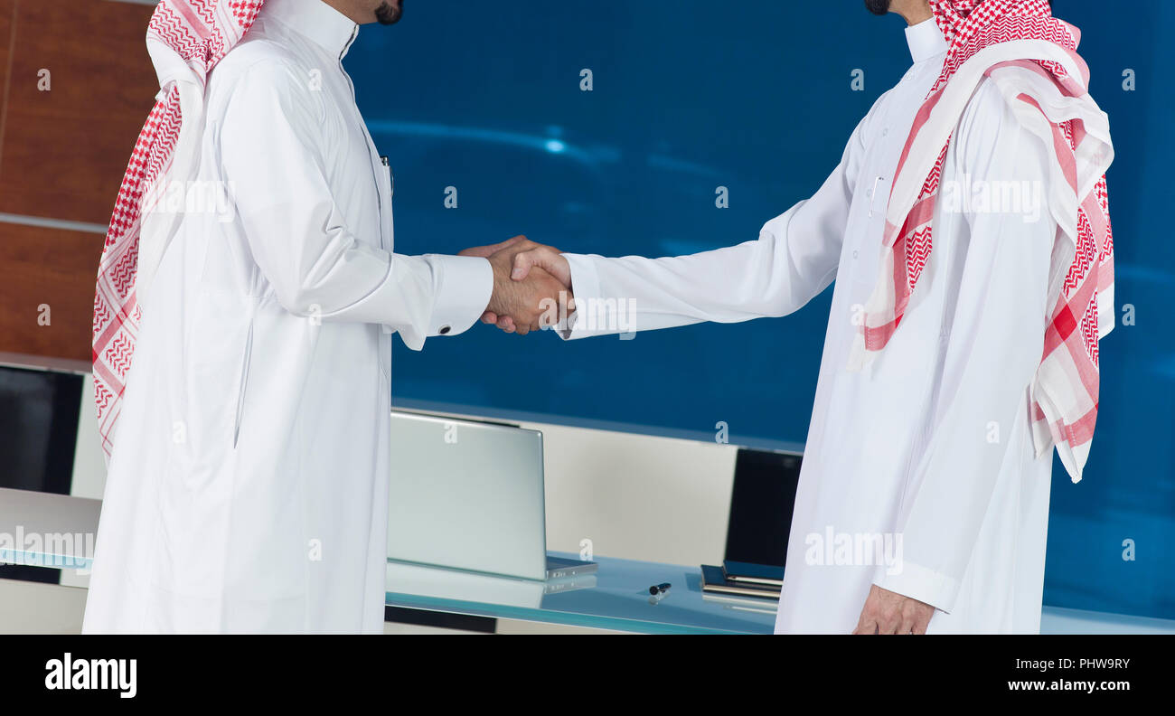 Middle eastern businessmen shaking hands, in an office environment ...