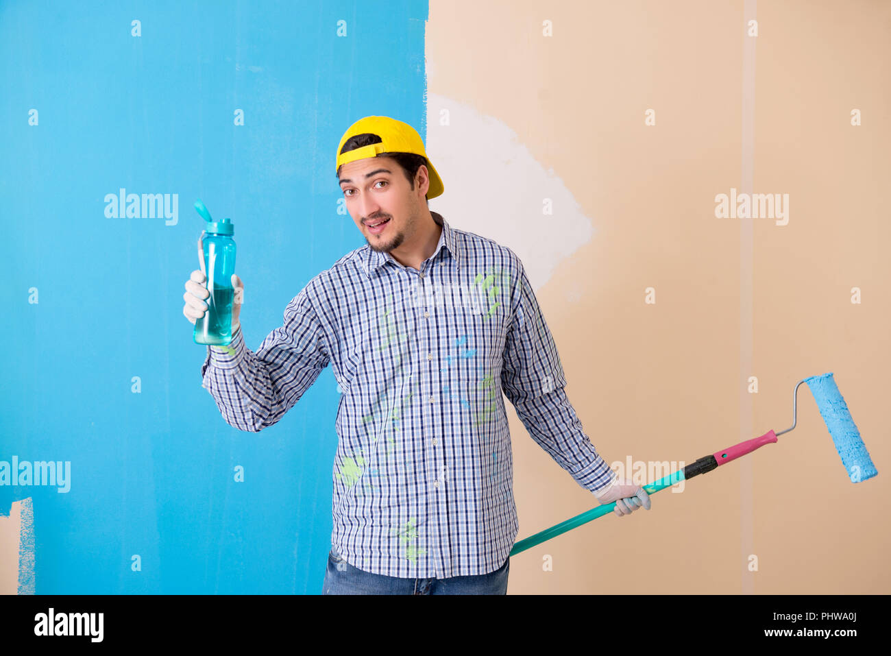 Painter man painting the wall at home Stock Photo - Alamy