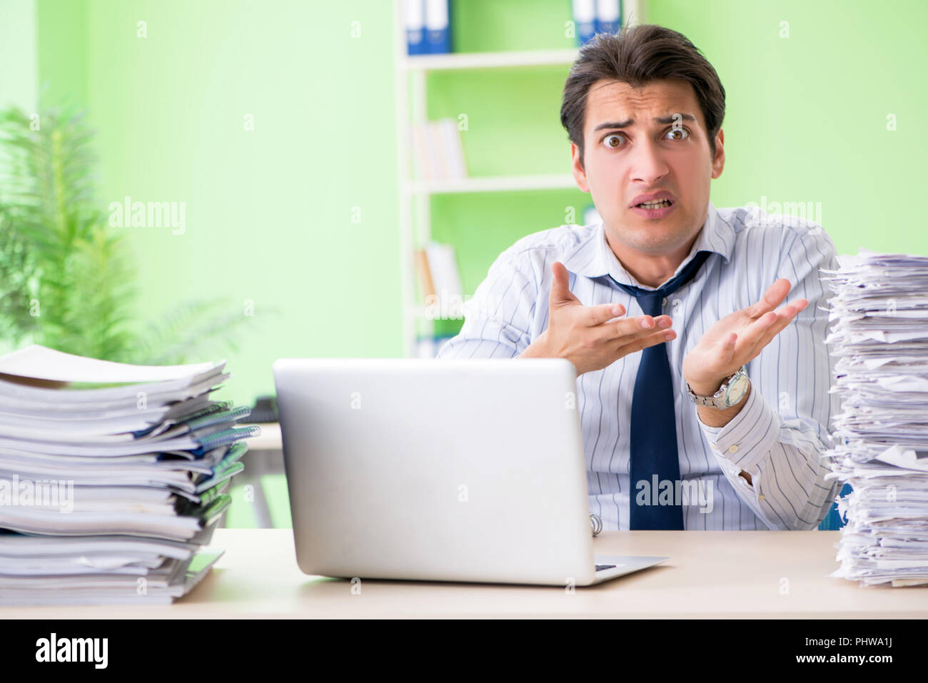 Businessman having problems with paperwork and workload Stock Photo - Alamy