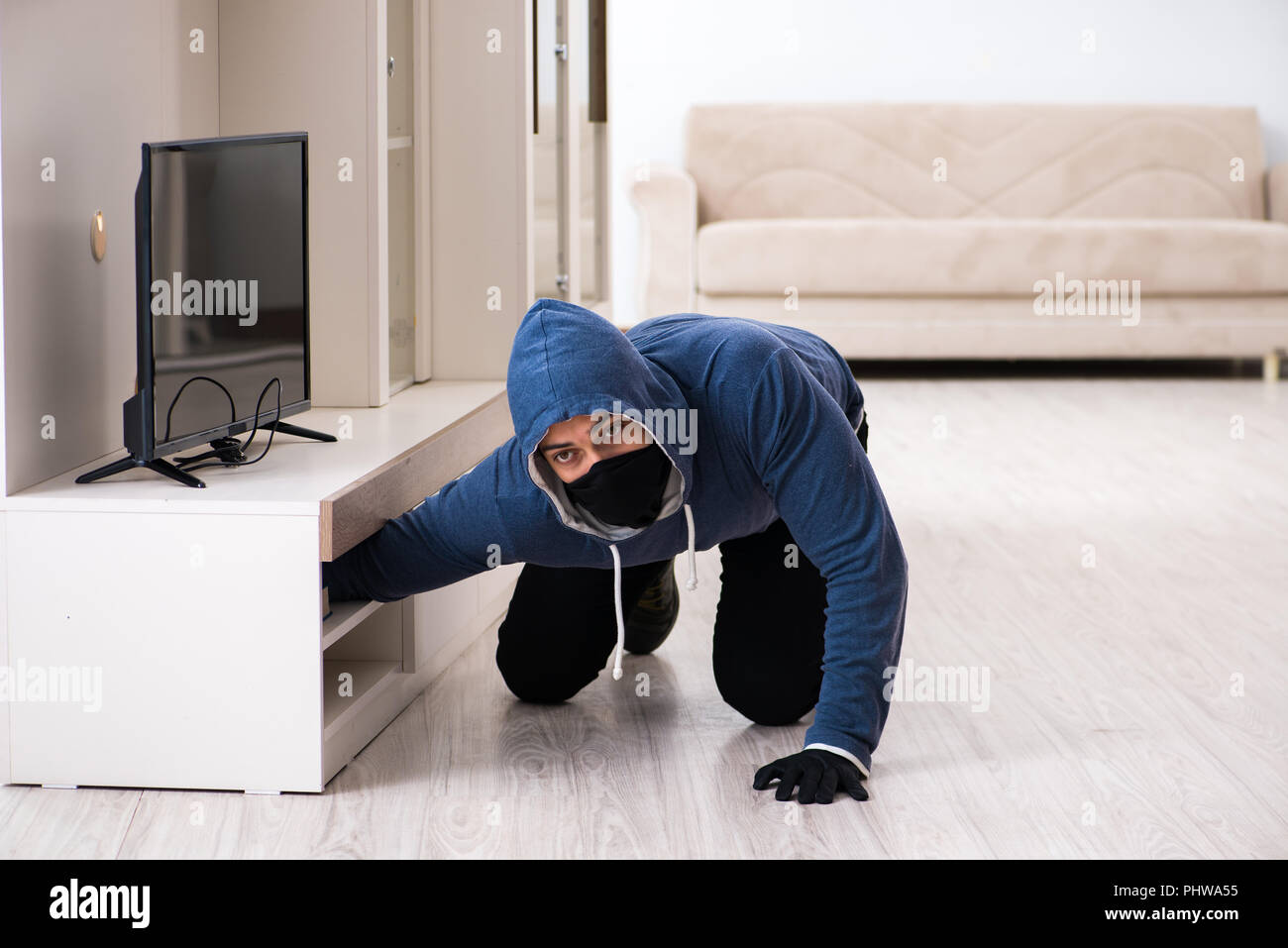 Man burglar stealing tv set from house Stock Photo - Alamy