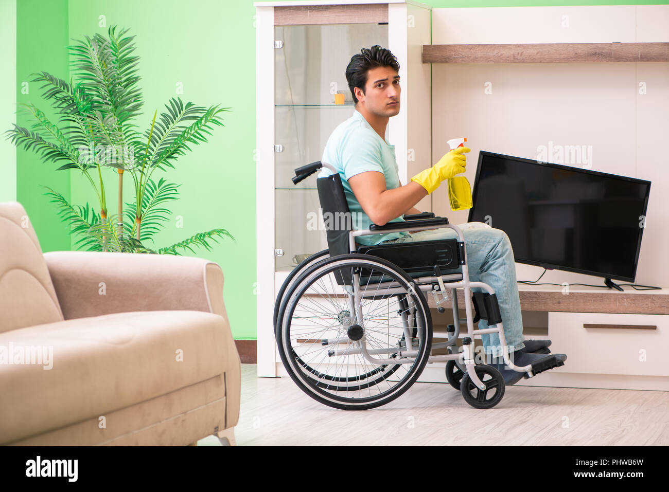 Disabled man on wheelchair cleaning house Stock Photo - Alamy