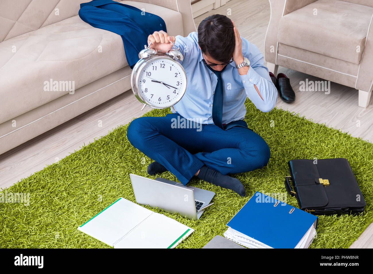 Businessman taking work home and working overtime Stock Photo - Alamy