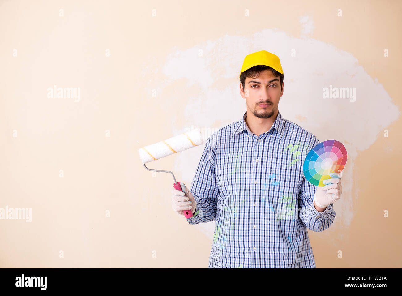 Painter man painting the wall at home Stock Photo - Alamy