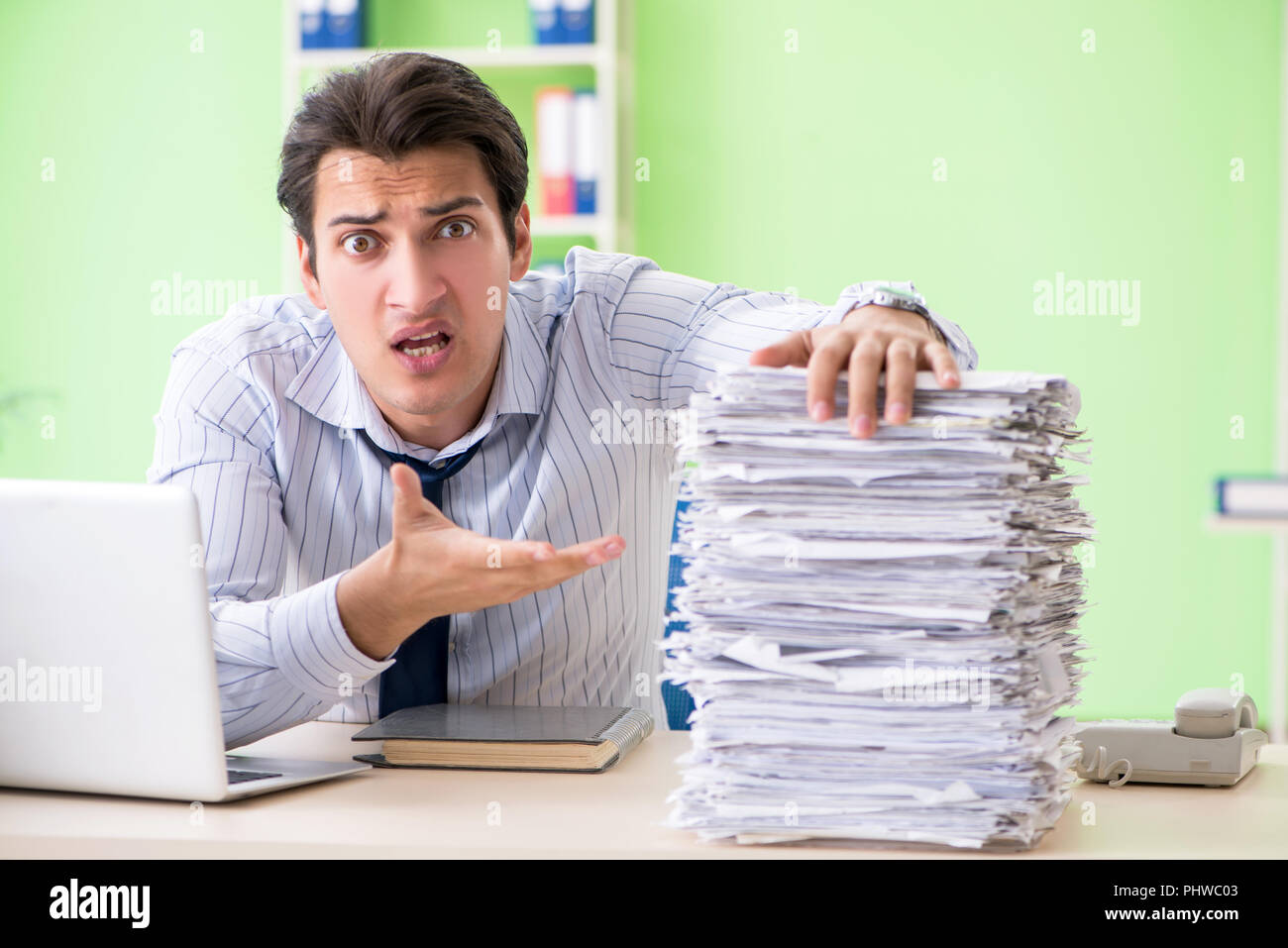 Businessman having problems with paperwork and workload Stock Photo - Alamy