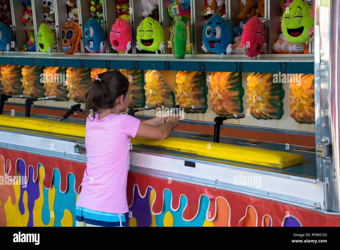 Young girl focused on winning a prize at water gun fun at the Matthews ...