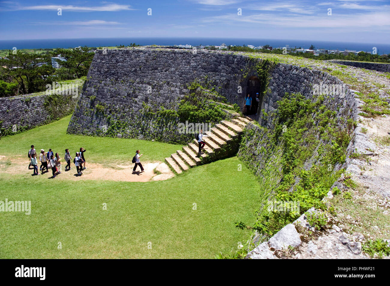 Visitors exit the gate leading to the main ward at Zakimi Castle ruins ...