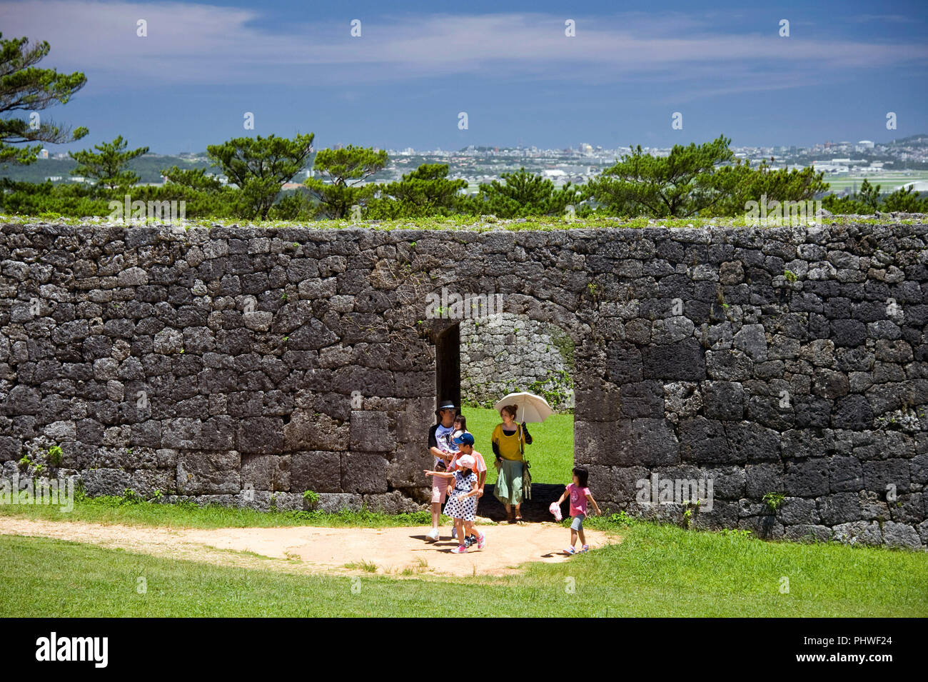 Visitors exit the gate leading to the main ward at Zakimi Castle ruins ...