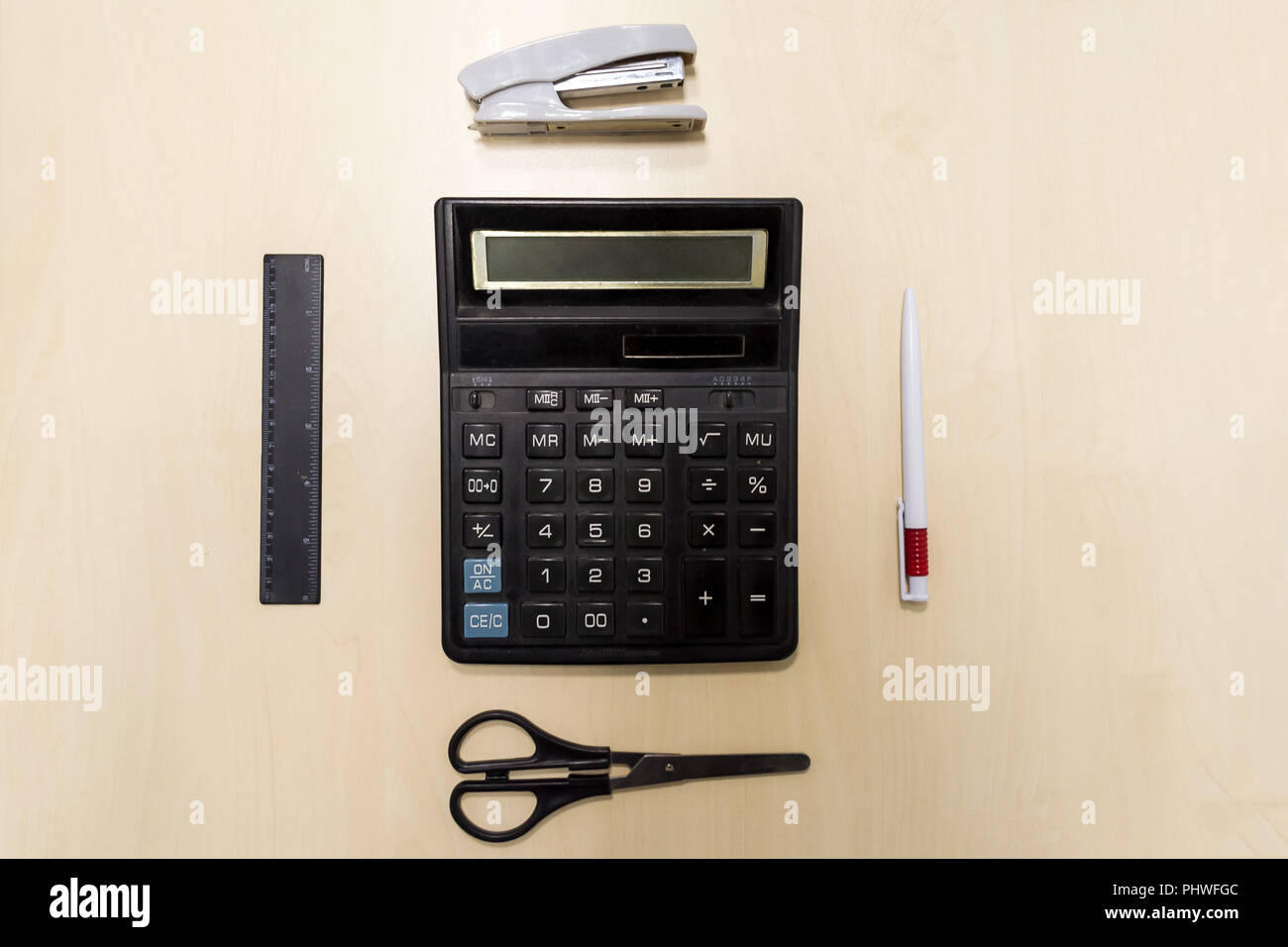A set of office tools consisting of a calculator, pen, stapler, ruler ...