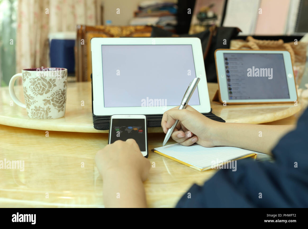Business woman making notes and using a tablet Stock Photo - Alamy