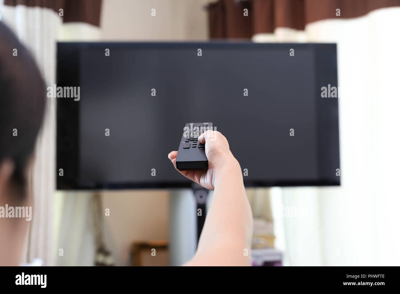 Watching tv and using remote control Stock Photo - Alamy