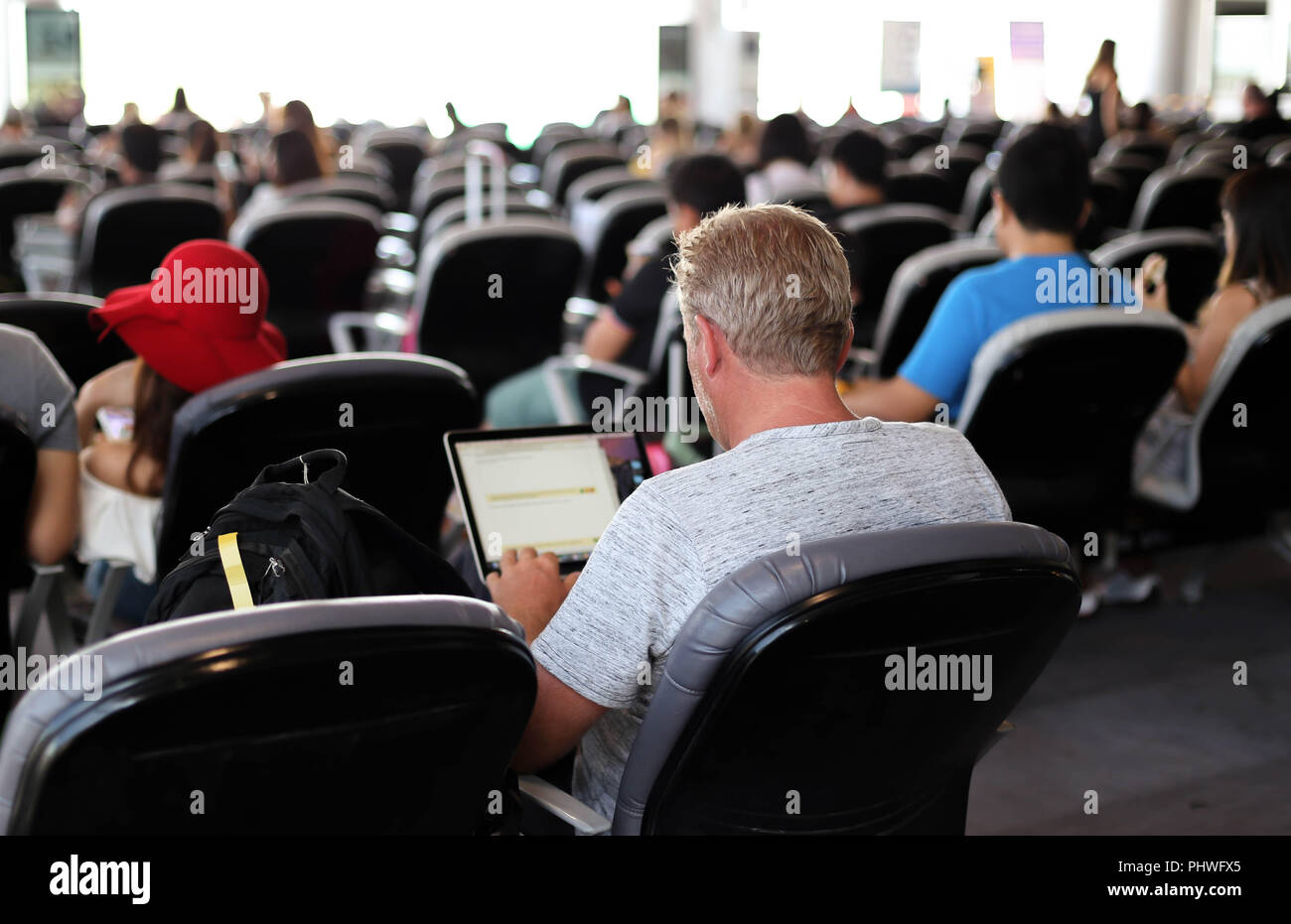 Passenger at the airport using his tablet computer Stock Photo - Alamy