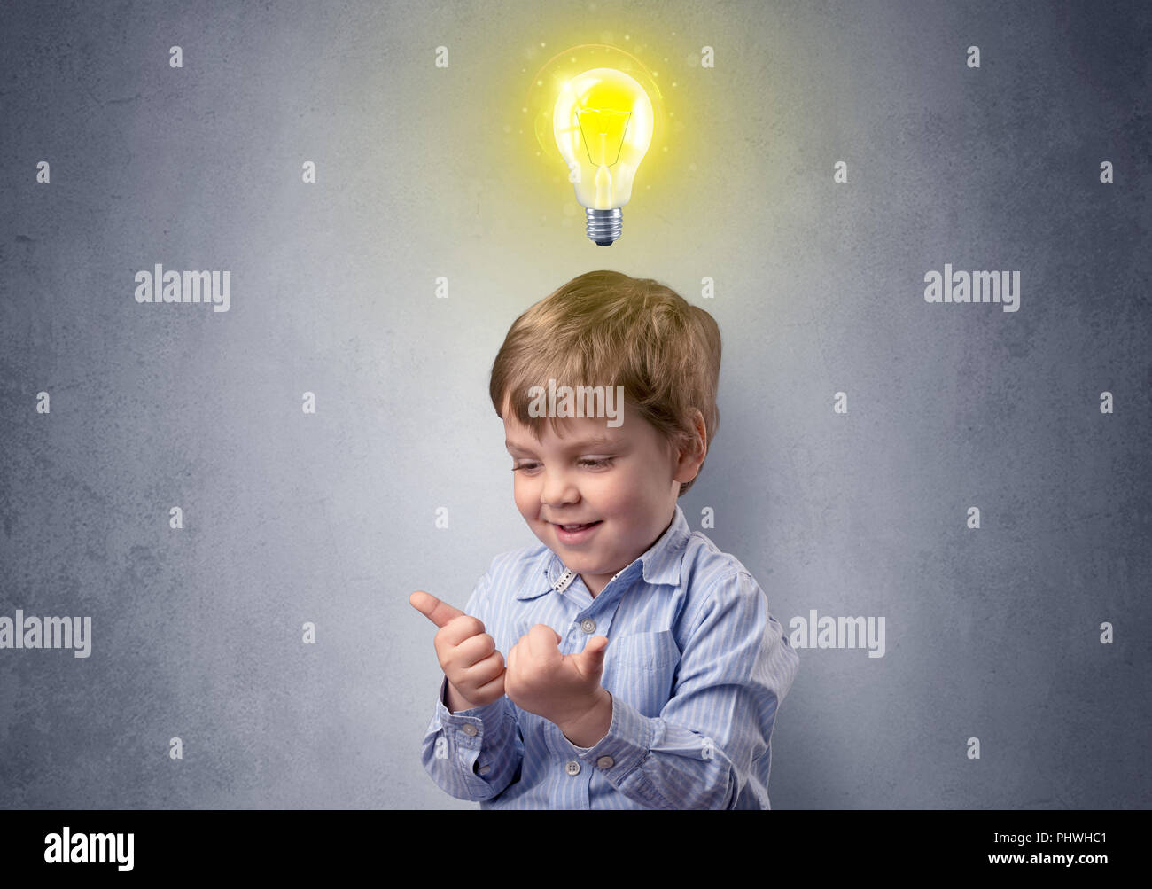 Adorable little kid mull over in front of a grey wall with idea symbol ...