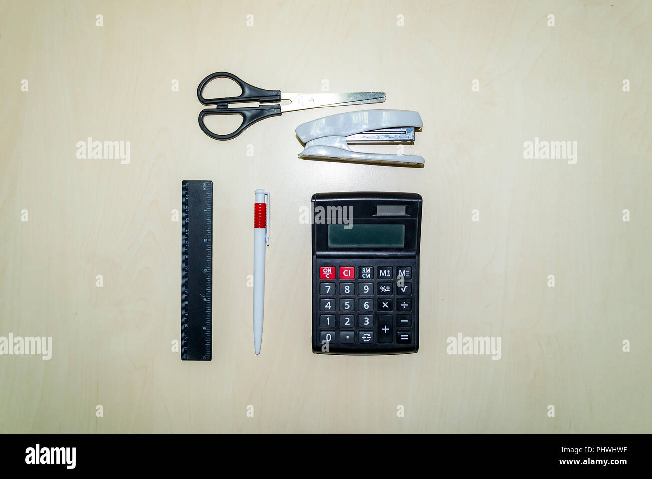 A set of office tools consisting of a calculator, pen, stapler, ruler ...