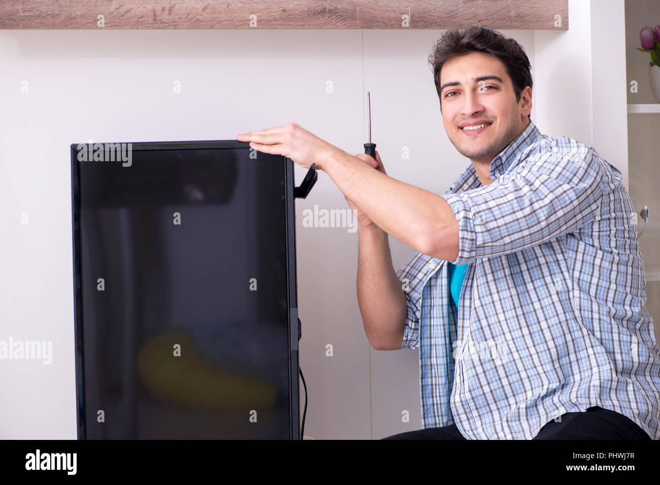 Man repairing broken tv at home Stock Photo - Alamy