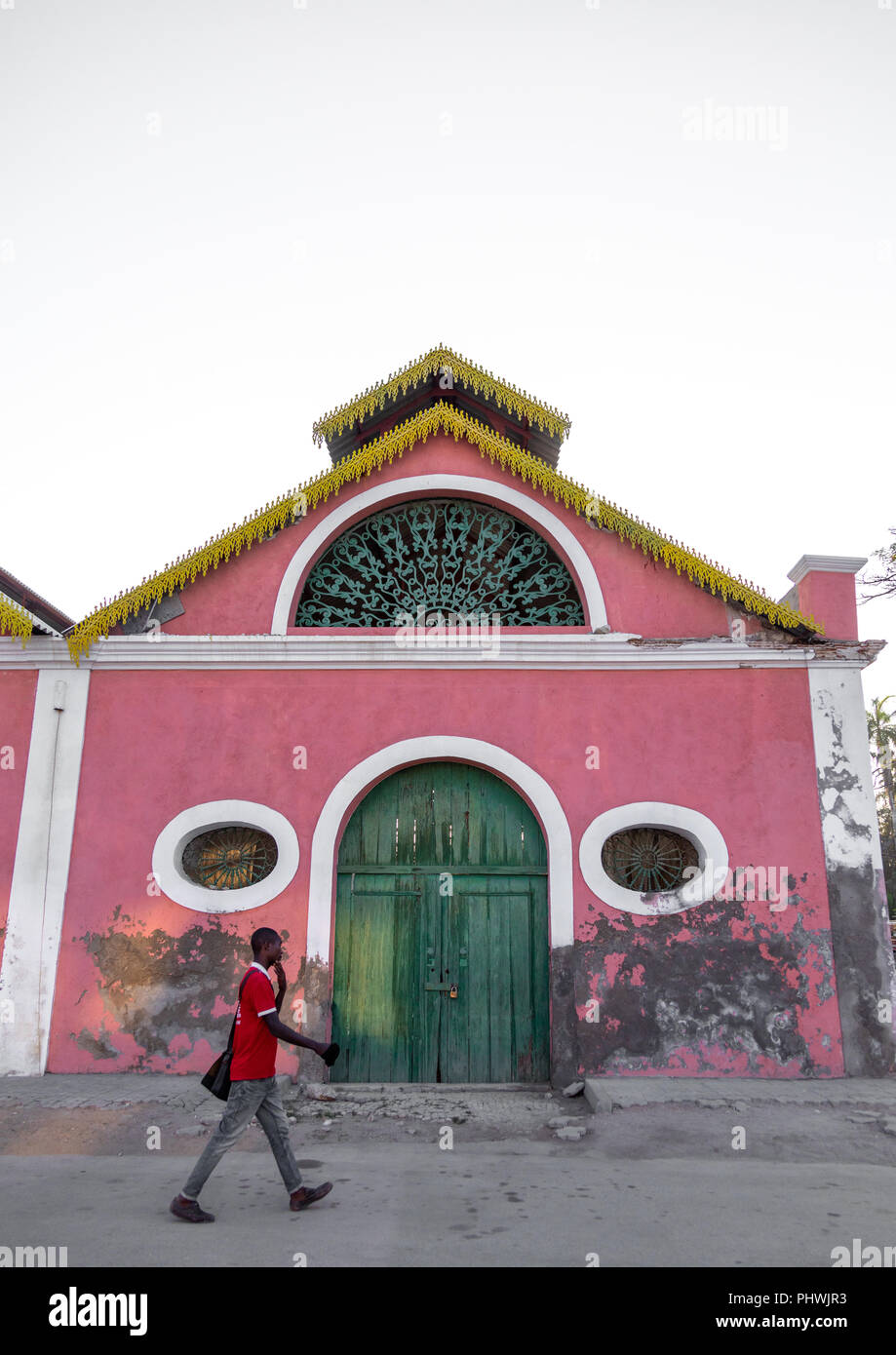 Angolan man passing in front of an old portuguese colonial warehouse ...
