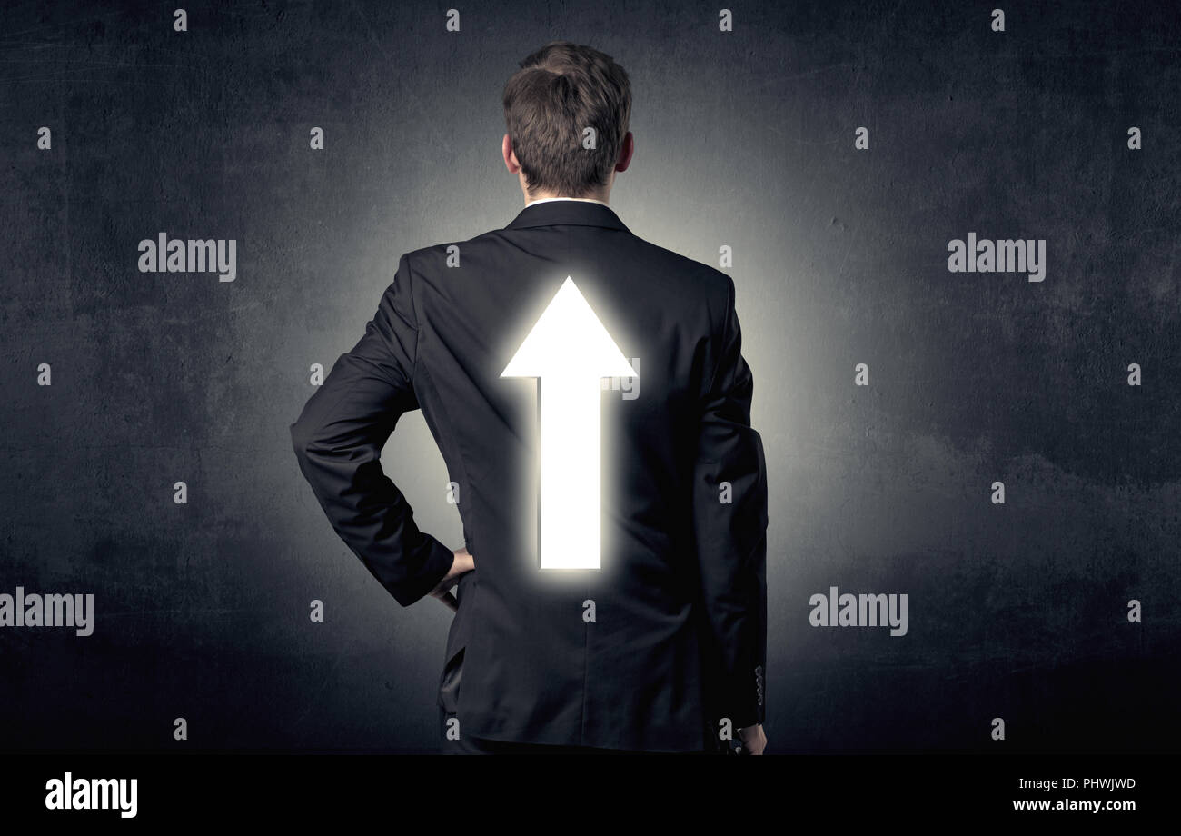 Young businessman standing and thinking about which direction to choose ...