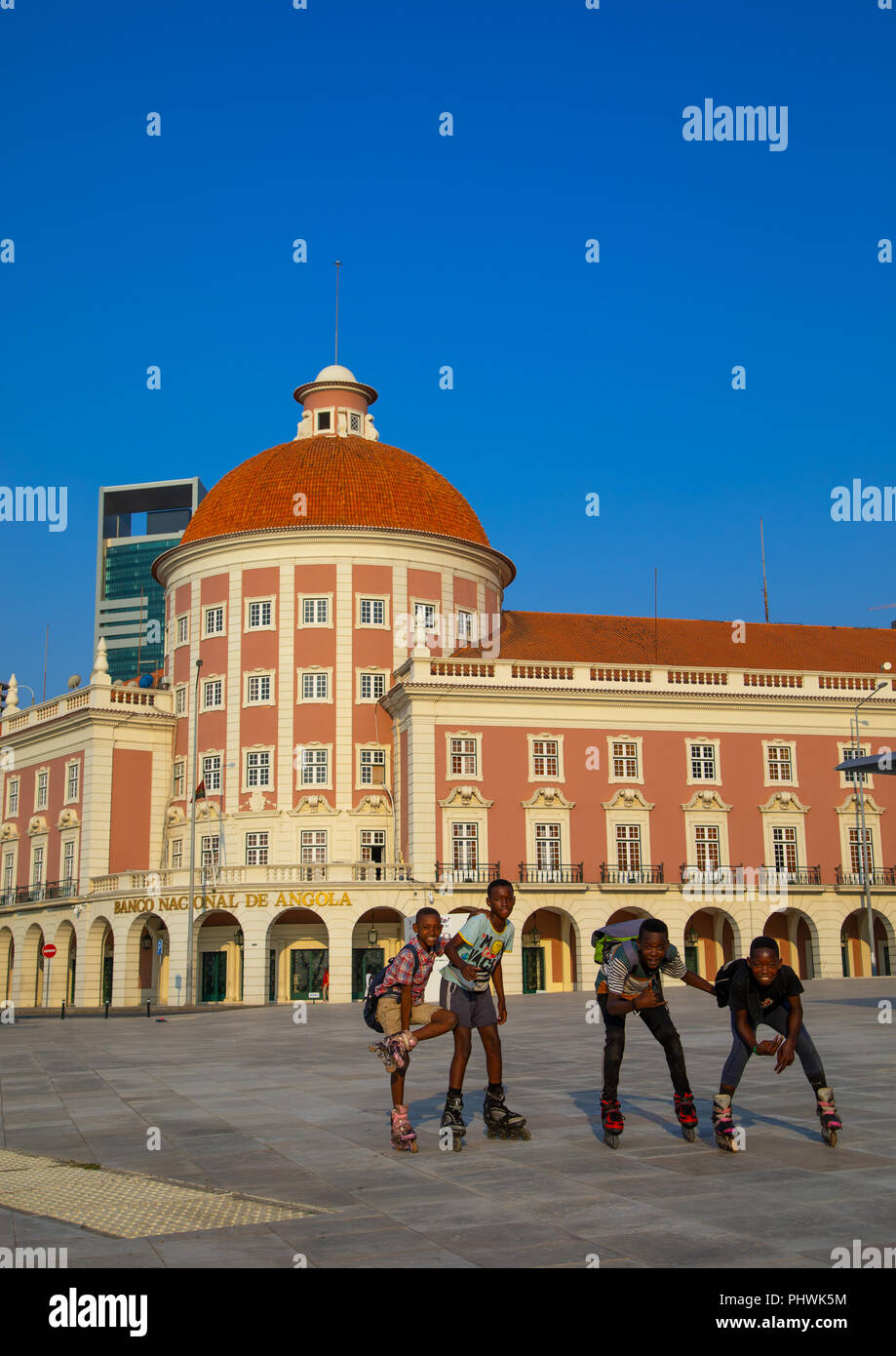 Angola teenage boys wirth roller skating in front of banco nacional de ...