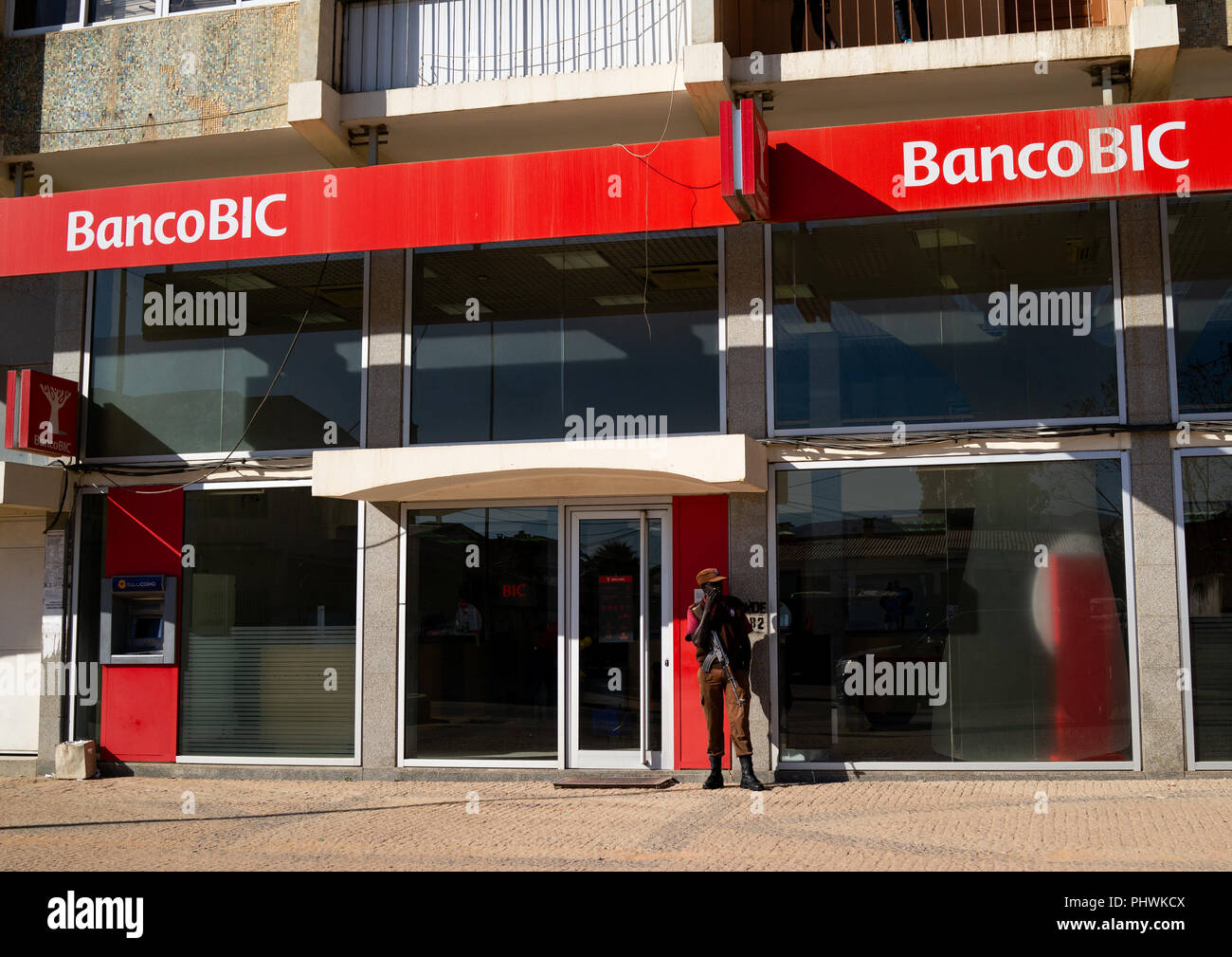Security guard standing in front of the entrance of a banco Bic , Huila ...
