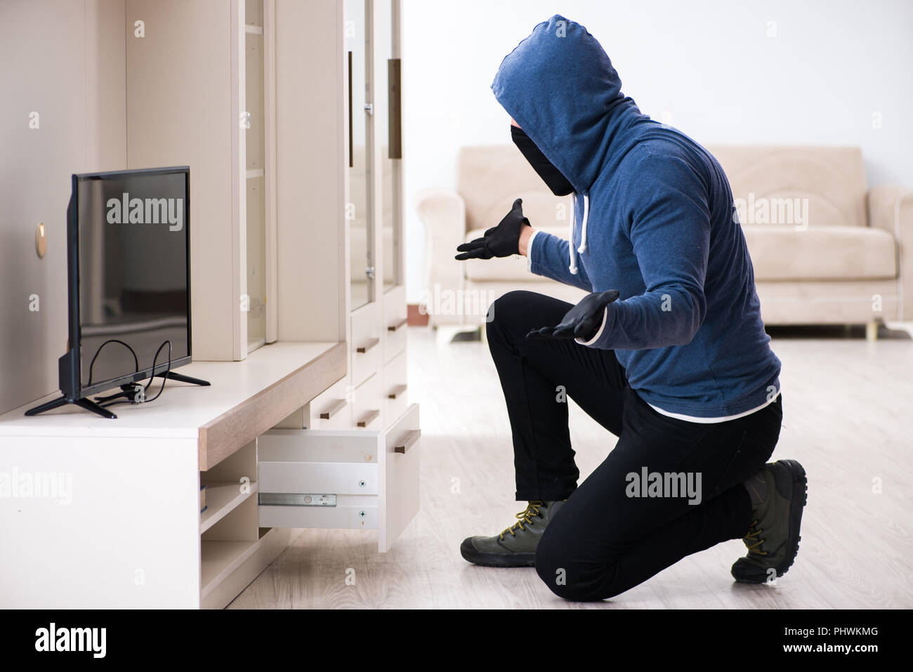 Man burglar stealing tv set from house Stock Photo - Alamy
