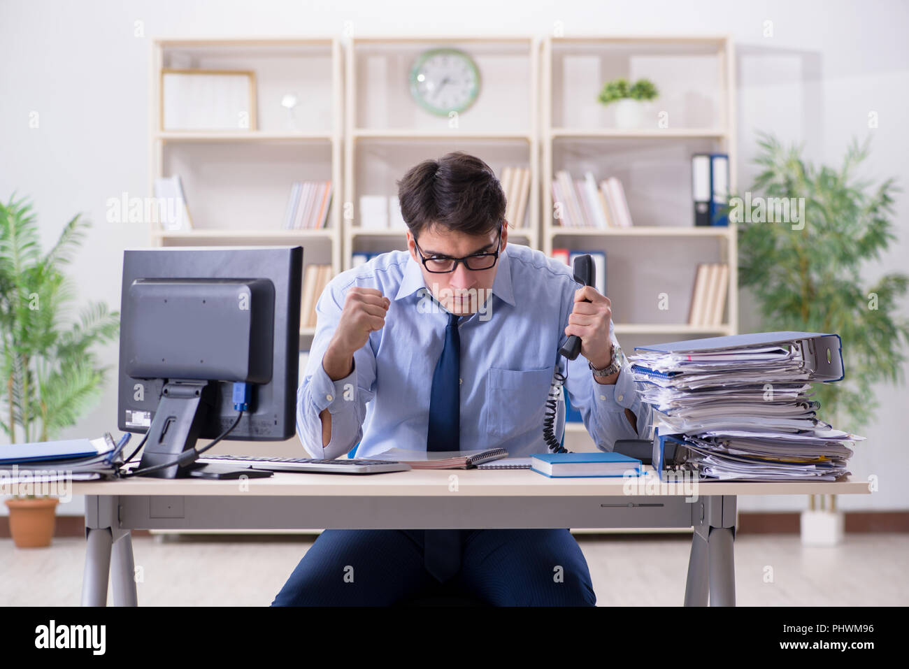 Angry businessman frustrated with too much work Stock Photo - Alamy