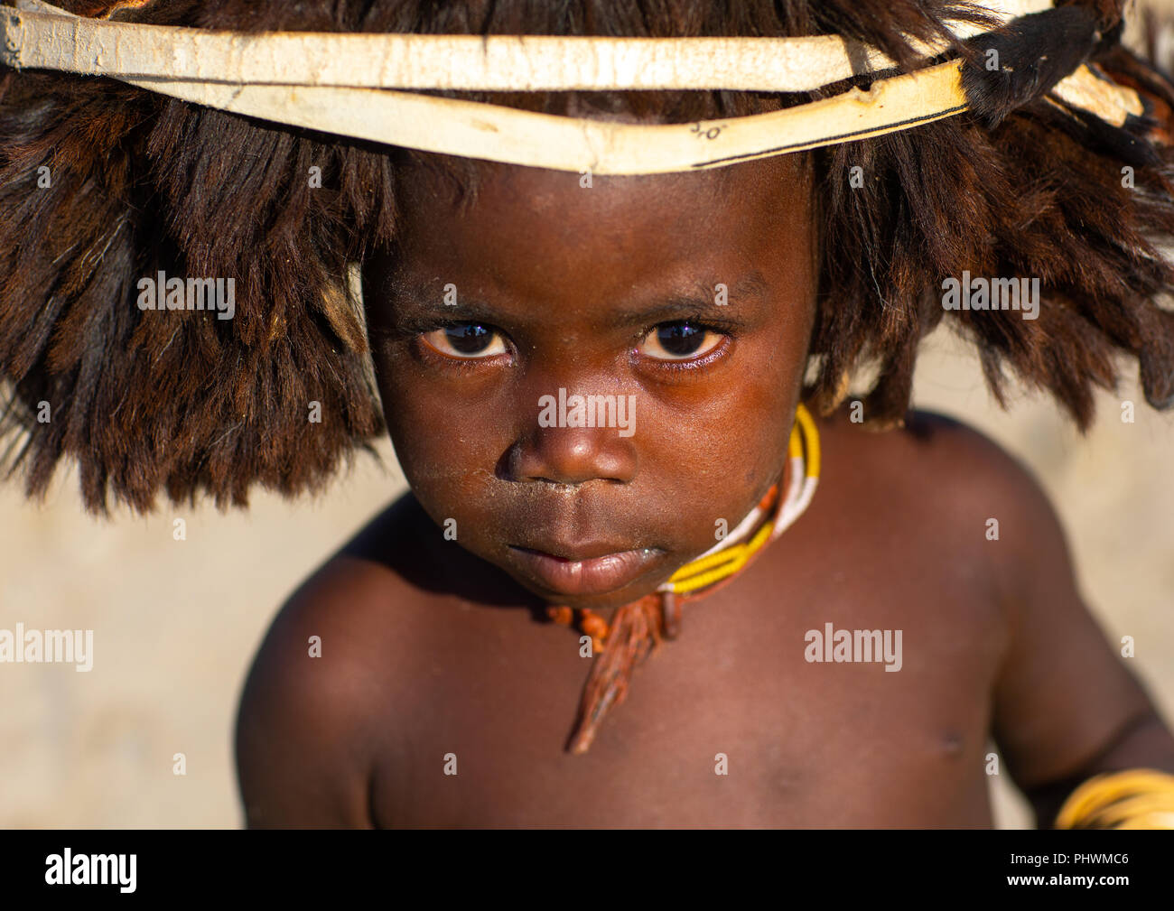 Cute mucubal tribe boy wearing a fur headwear, Namibe Province, Virei ...