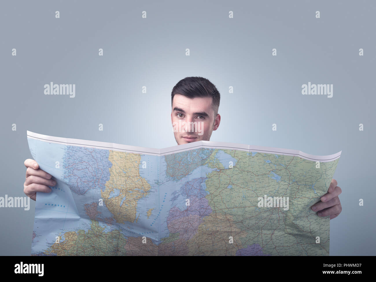 Handsome young man holding map Stock Photo - Alamy
