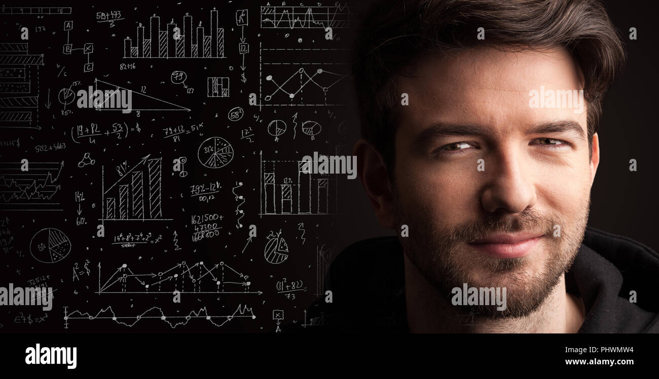 Portrait of a young businessman with charts and graphs scribbled next ...