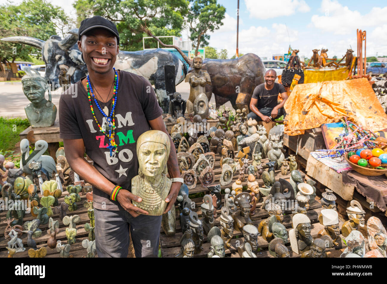A curio seller holds up a stone carving in Harare Zimbabwe Stock Photo ...