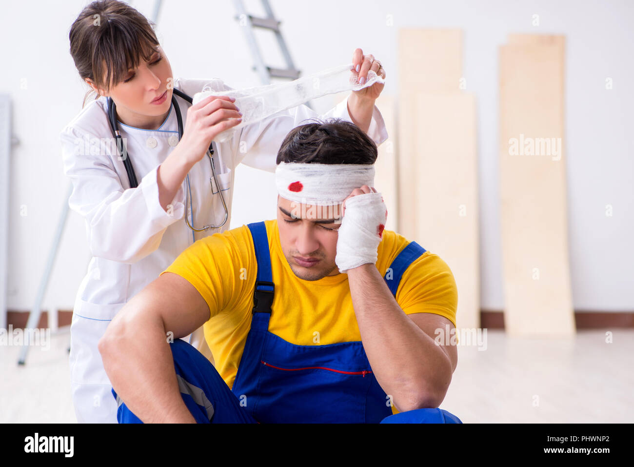 Worker with injured head and doctor Stock Photo - Alamy