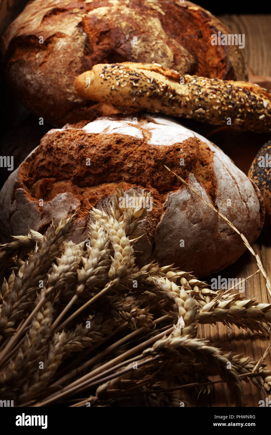 Different kinds of bread and bread rolls on board from above. Kitchen ...