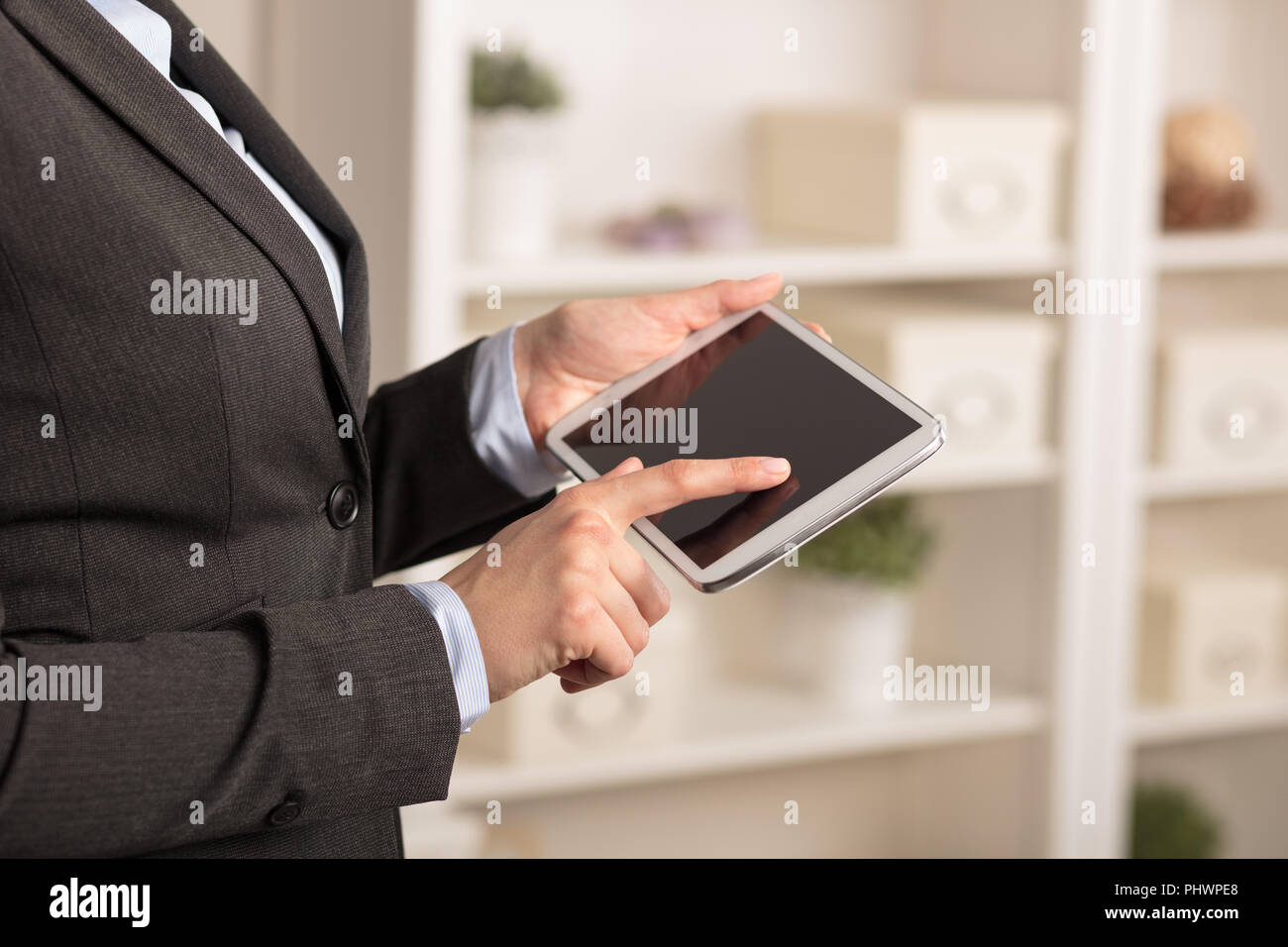 Business woman below chest using tablet in a homey environment Stock ...