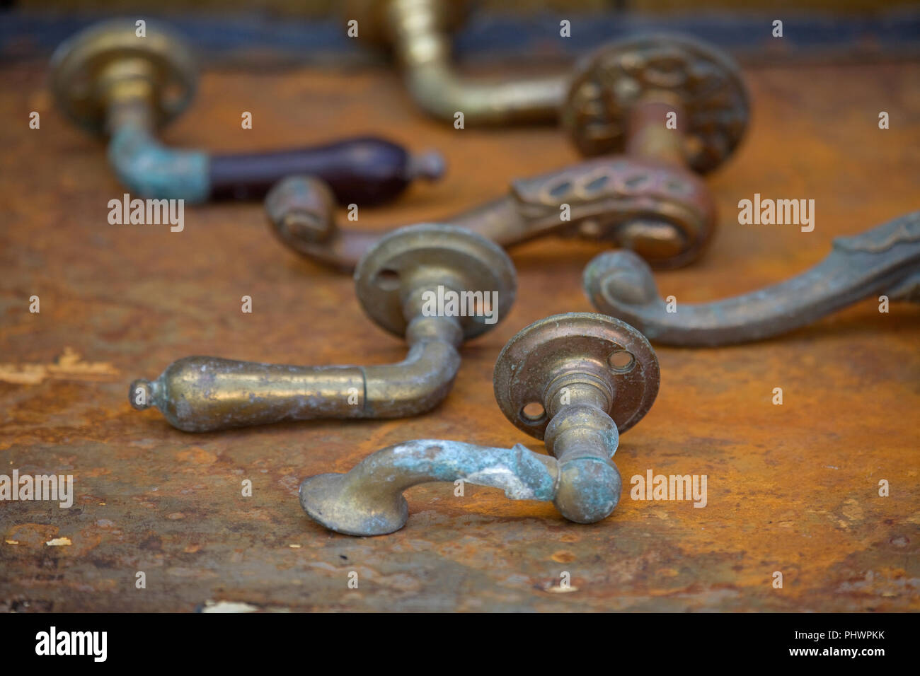 old metal door handles on rusty table top Stock Photo - Alamy