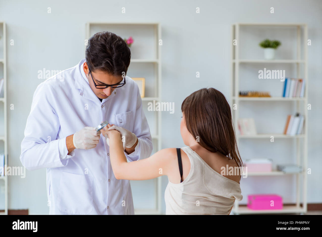 Doctor examining the skin of female patient Stock Photo - Alamy