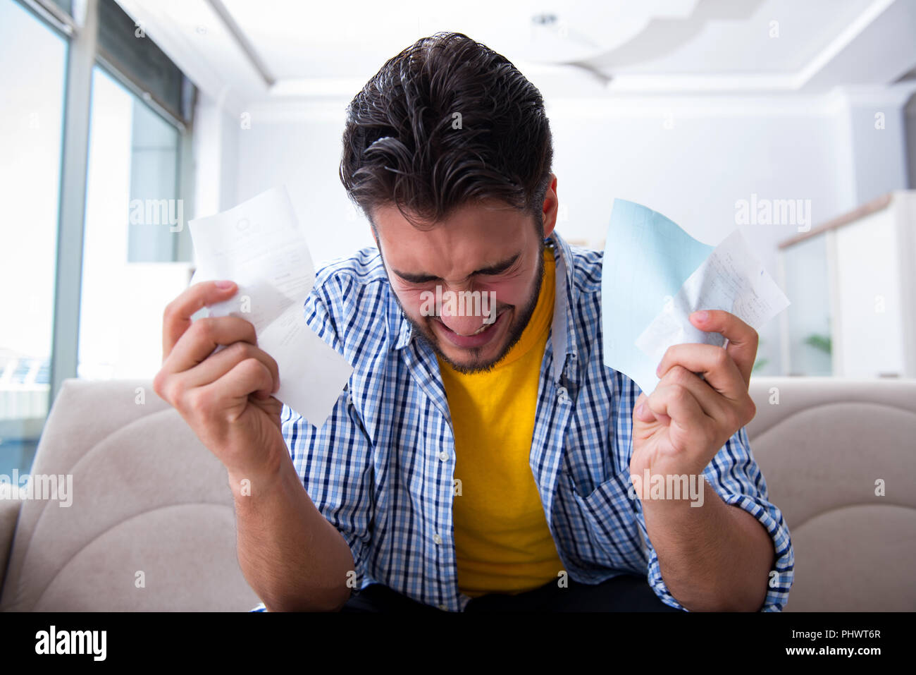 Man angry at bills he needs to pay Stock Photo - Alamy