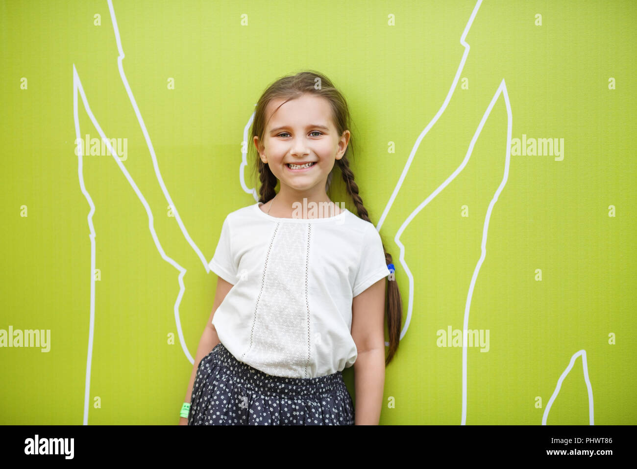 Smiling little girl child on light green background. Concept of happy ...