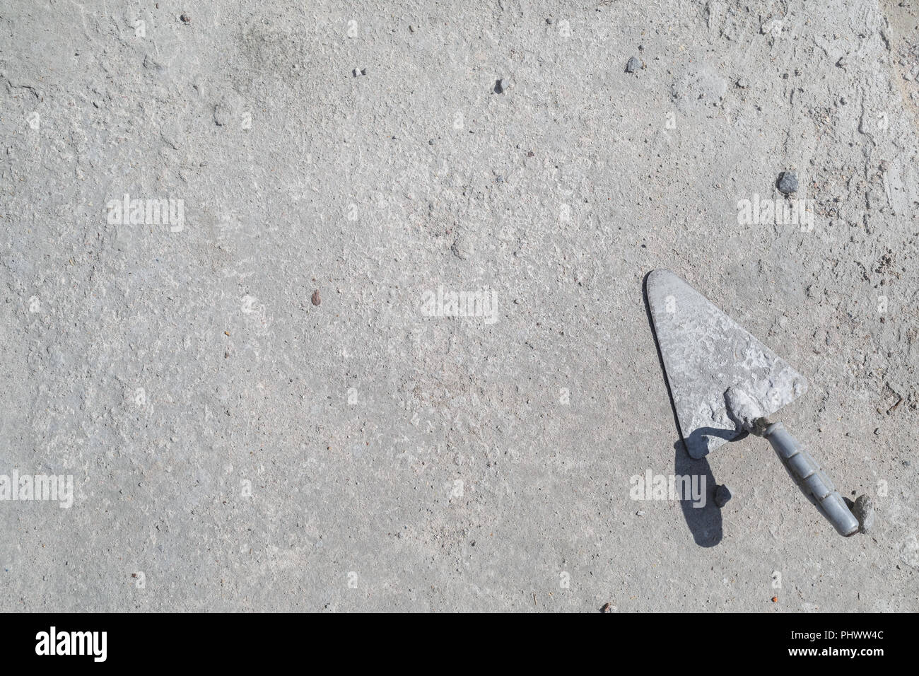 Used masonry trowel on concrete background. Space for text. Flat lay ...