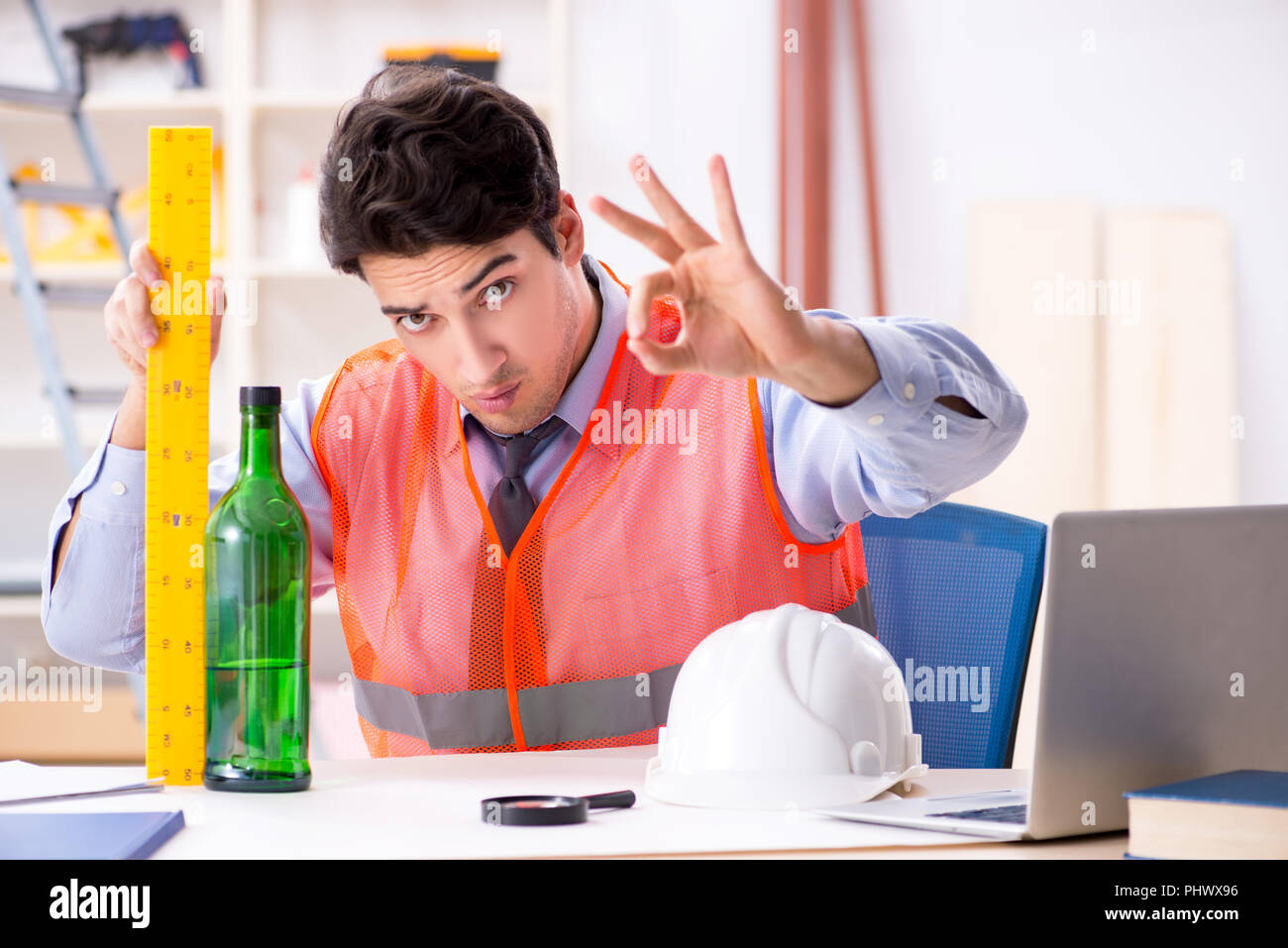 Drunk engineer working in the workshop Stock Photo - Alamy