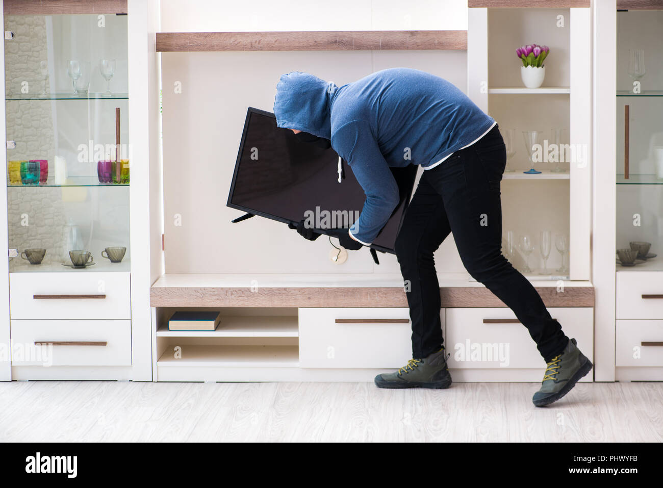 Man burglar stealing tv set from house Stock Photo - Alamy